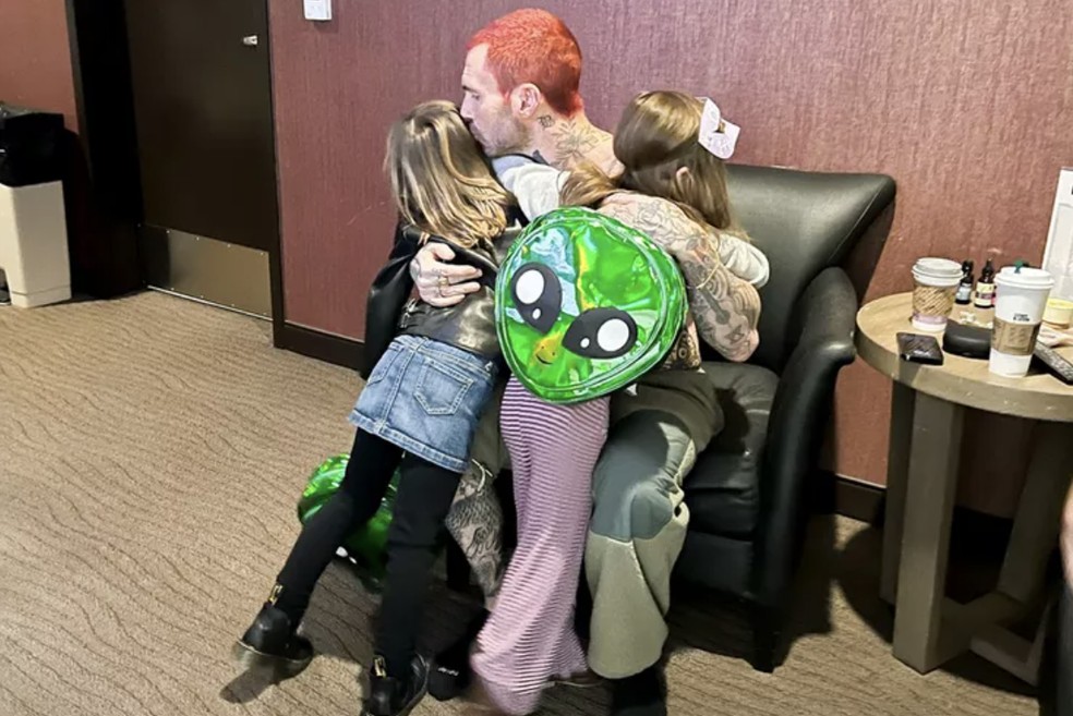 Adam Levine é clicado pela esposa em momento de carinho com as filhas