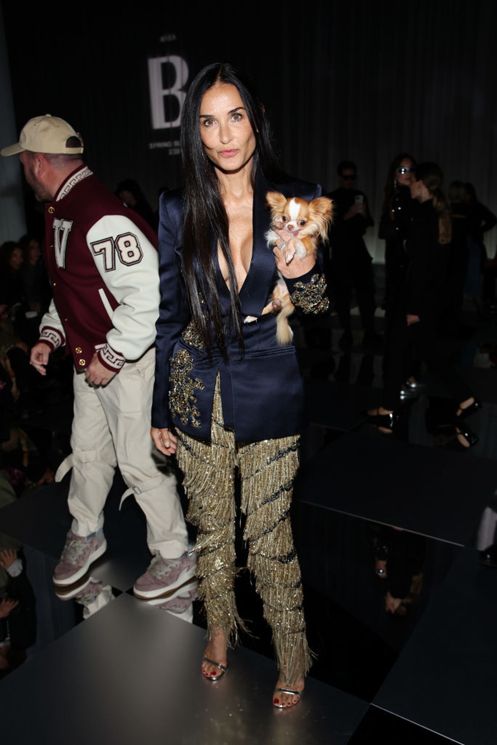 Demi Moore leva cachorro para a fila A do desfile da Versace