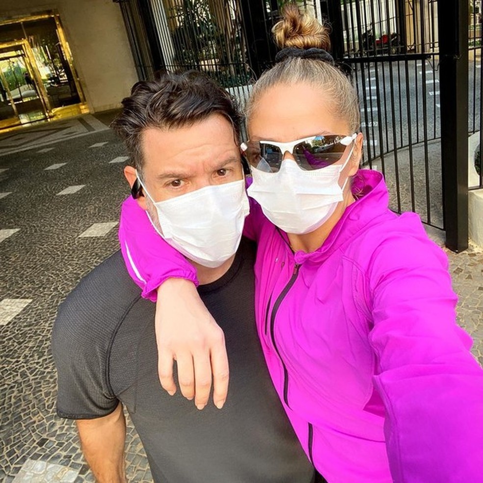 Adriane Galisteu sai para correr com o marido de máscara e look poderoso
