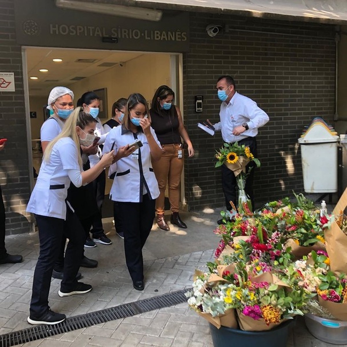 Floristas distribuem flores para profissionais da saúde em hospital
